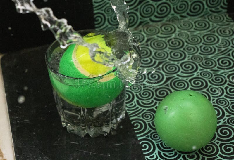 Experiment with Fast Shutter Speed. Tennis Ball Falling into the Glass ...