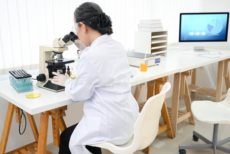 An Expert Asian Female Scientist Supervisor Examining a Virus Specimen ...