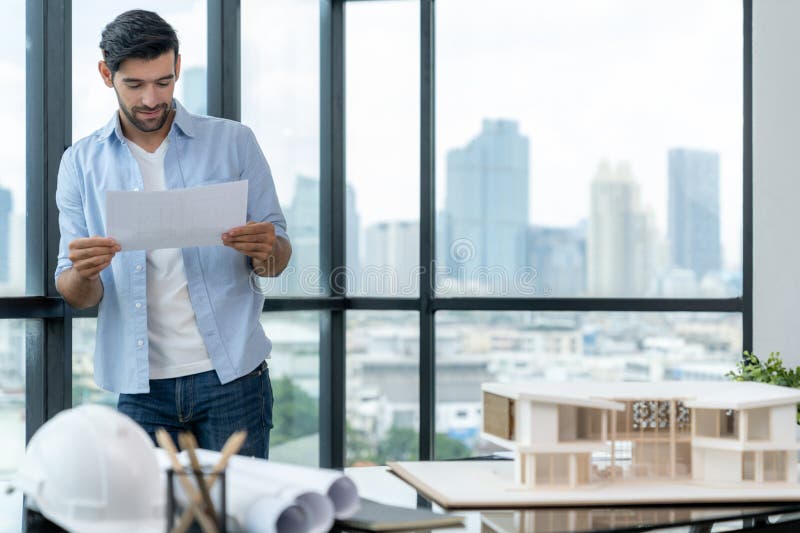 Expert Engineer Holding Blueprint while Comparing with House Model ...
