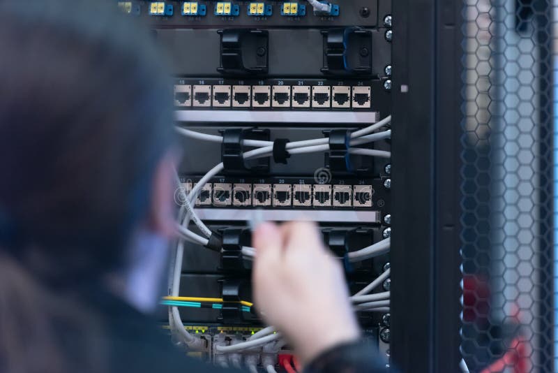 An Expert Engeneer in Datacenter Server Room Connecting Cables in ...