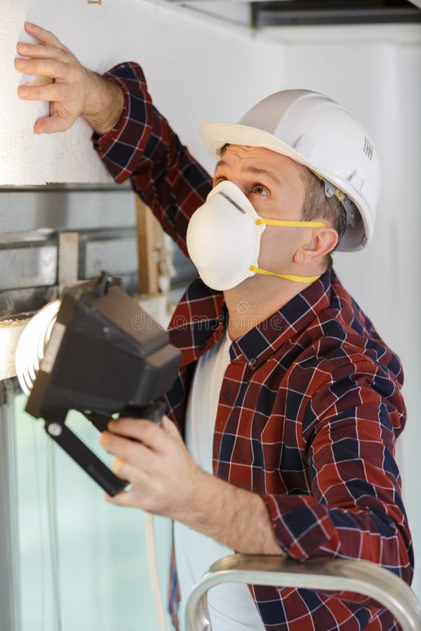 Man Inspecting Insulation in Building Stock Photo - Image of ...
