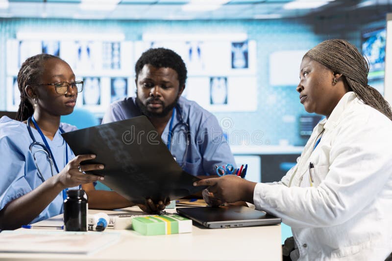 Expert Physician Explaining Scans To Team of Nurses Interns in the ...