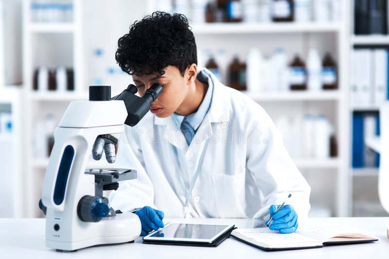 The Expert Will Solve it. a Young Scientist Using a Microscope in a Lab ...