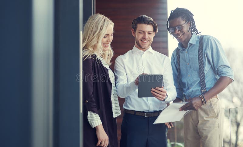 Explaining His Idea. Three Young Businesspeople Using a Tablet while ...