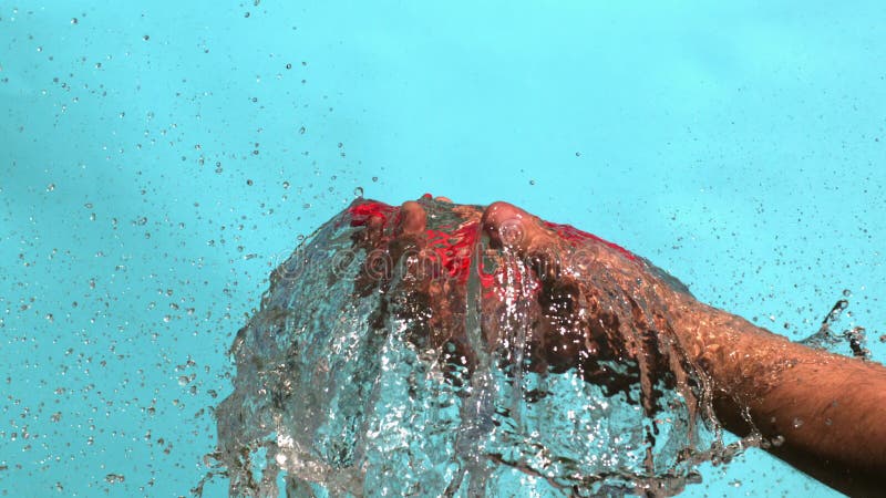 Explosion of Blue Water Balloon in a Palm on a Terracotta Background in ...