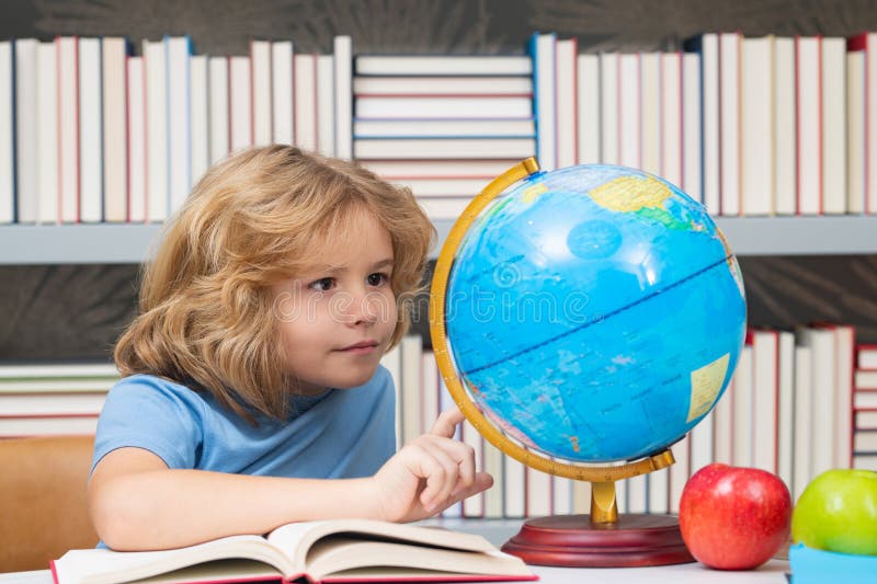 Explorer and Discovery. School Pupil Looking at Globe in Library at the ...