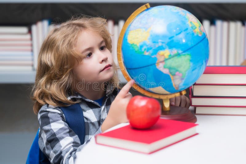 Explorer and Discovery. School Pupil Looking at Globe in Library at the ...