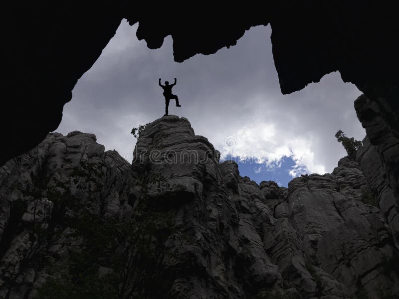 Explorer at the Entrance of a Great Cave at the Top of the Mountains ...