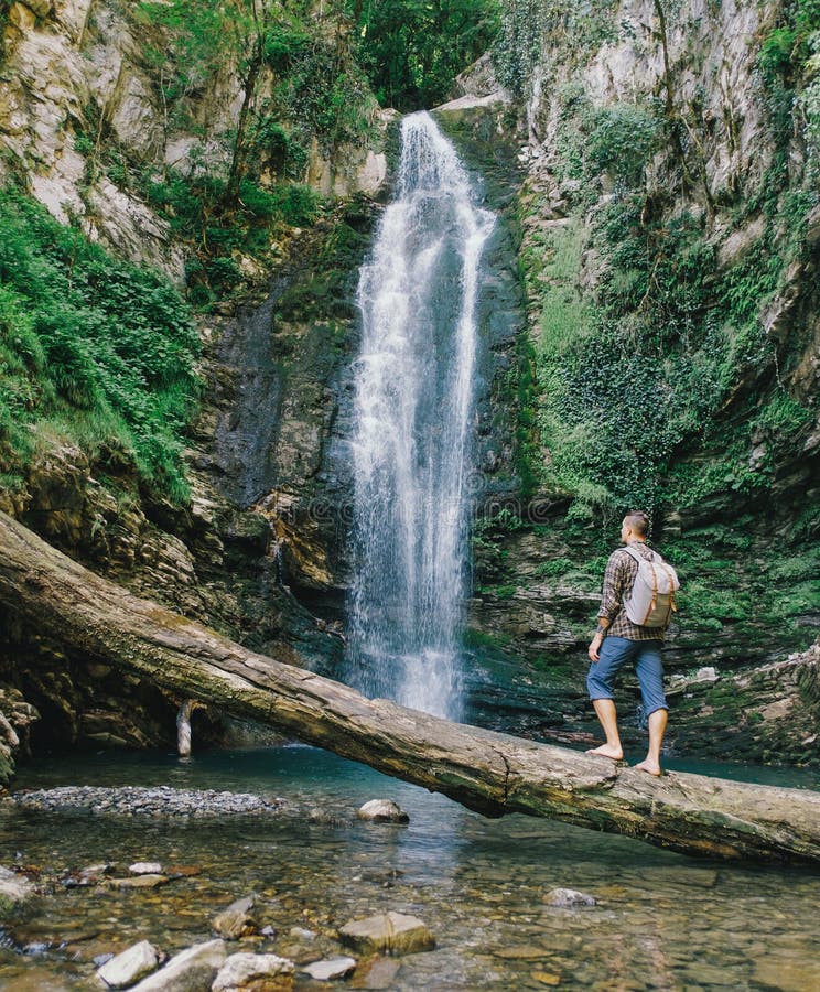 Explorer Man Looking at Waterfall. Stock Image - Image of young ...