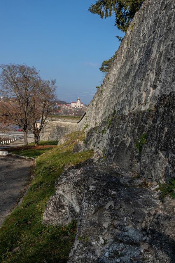 Exploring the Ancient Stone Wall by the River with a View of the Town ...
