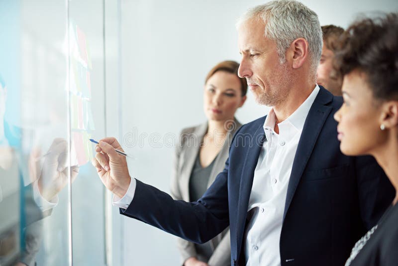 Exploring Different Ways To Work Their Project. Shot of a Group of ...