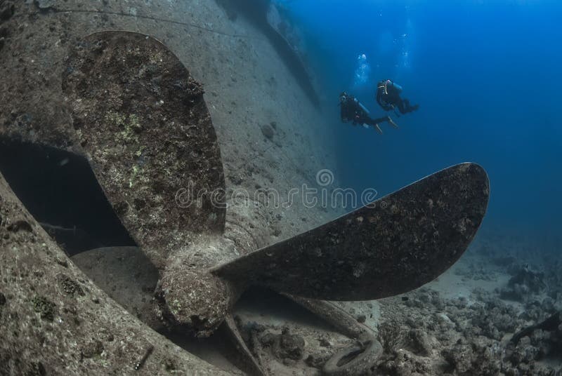 Exploring History: Divers at the Thistlegorm Wreck Propeller in the Red ...