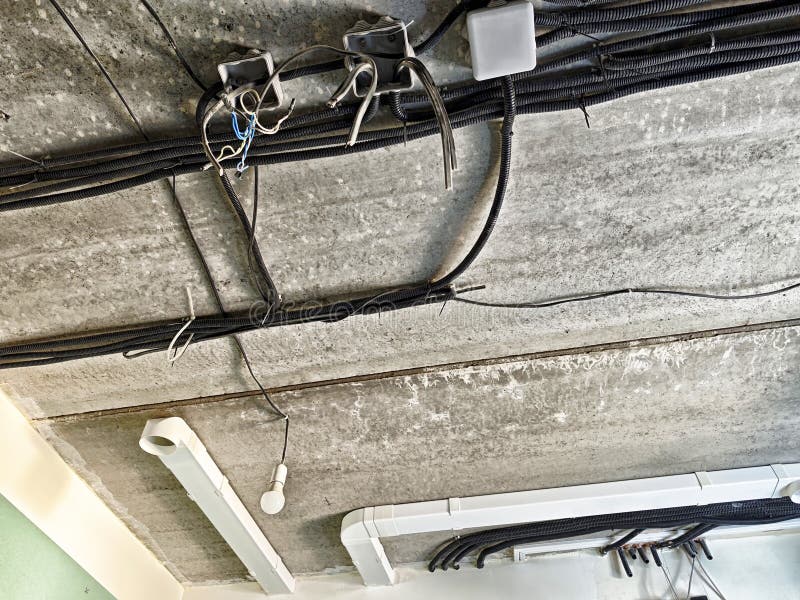 Exposed Electrical Wiring and Conduits Along a Gray Concrete Ceiling in ...