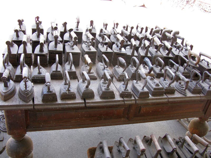 Extensive Collection of Vintage Irons Displayed Neatly on a Wooden ...
