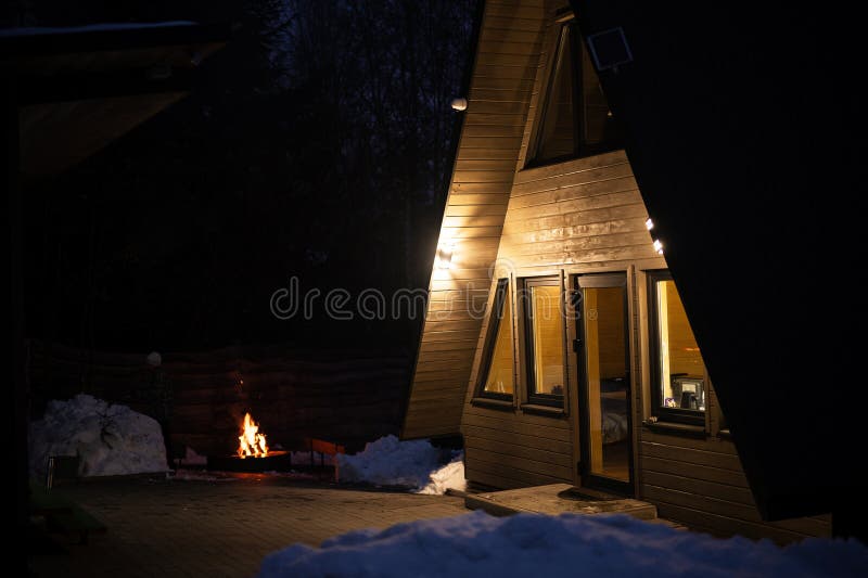 Exterior at Dusk of Modern Triangle Log Cabin in the Mountains with ...