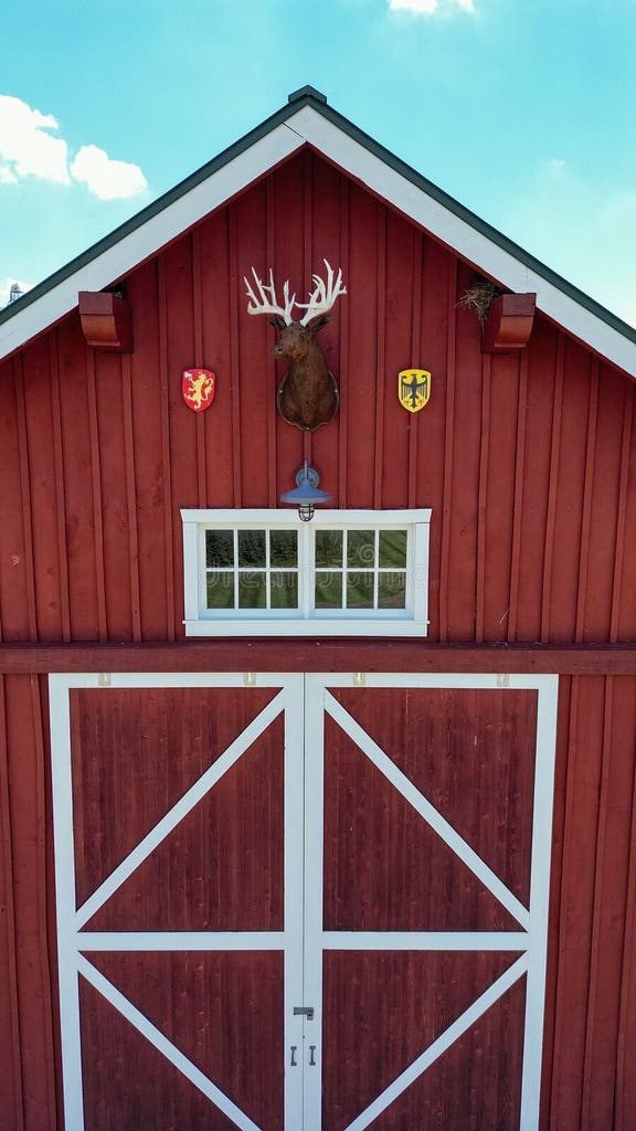 Exterior View of a Red and White Barn with a Mounted Deer Head on it ...