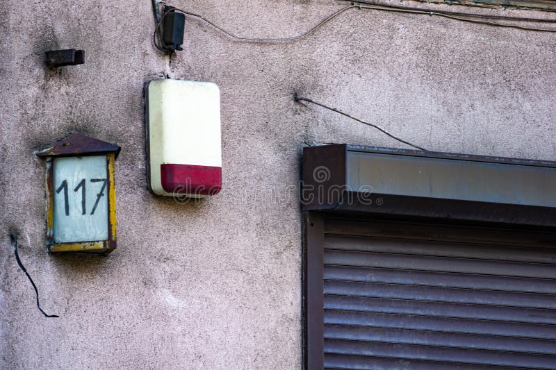 Number 117 on a Building Wall with a Closed Shutter and a Security ...