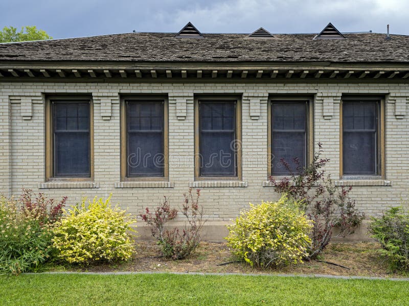 The Exterior Wall of a Tan Brick Building with Triangular Roof Vents ...
