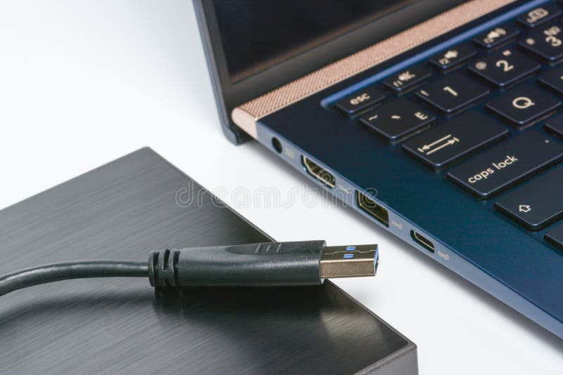 External Hard Drive with a USB 3.0 Cable and a Laptop Nearby. Concept ...