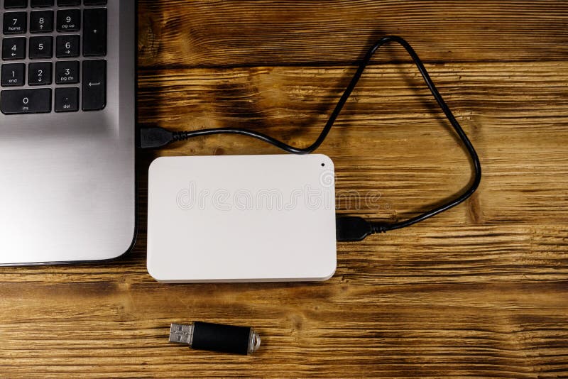 External HDD Connected To Laptop Computer and USB Flash Drive on Wooden ...