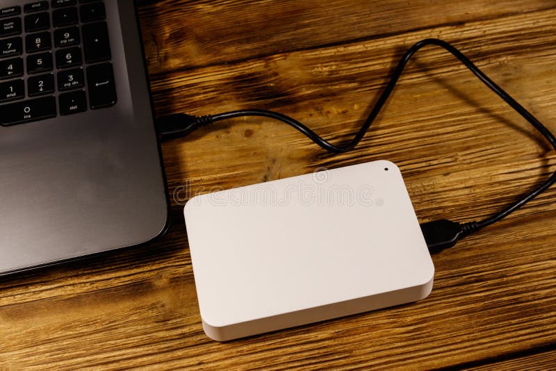 External HDD Connected To Laptop Computer on Wooden Desk. Concept of ...