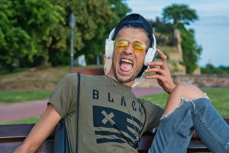 Extravagant Hipster Male Model is Singing on a Wooden Bench. Stock ...