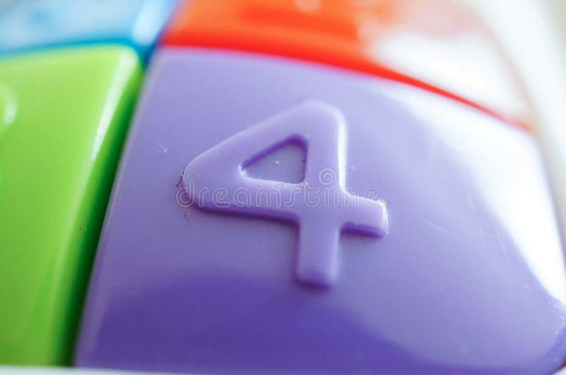 Extreme Closeup of a Purple Button of a Toy with the Number Four on it ...