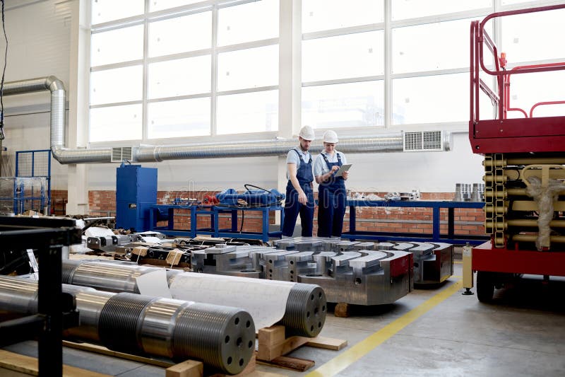 Two Workers Examining Objects Produced in Factory Stock Photo - Image ...