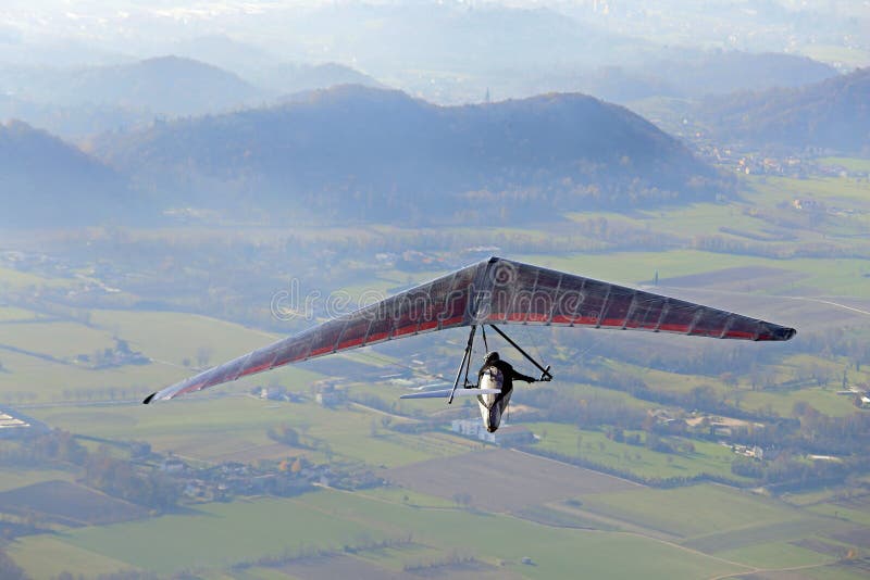 Man Flying with Hang Glider Above the Plain. this is Extreme Spo Stock ...