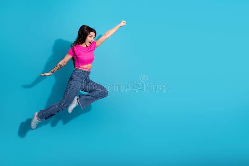 Energetic Young Woman in Casual Stylish Outfit Jumping Joyfully Against ...