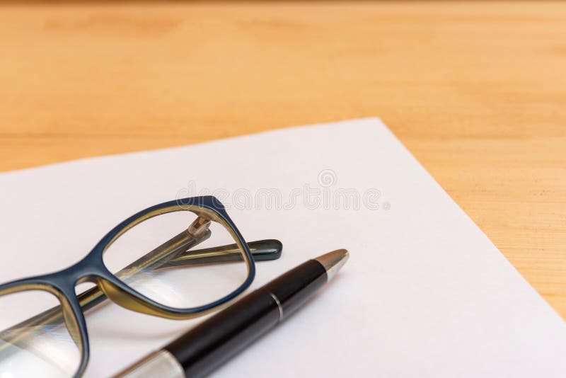 Eyeglasses and a Pen Lie on a Clean and White Sheet of Paper for ...