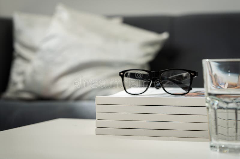 Eyeglasses with Stack of Books, and the Glass of Water on the Table ...