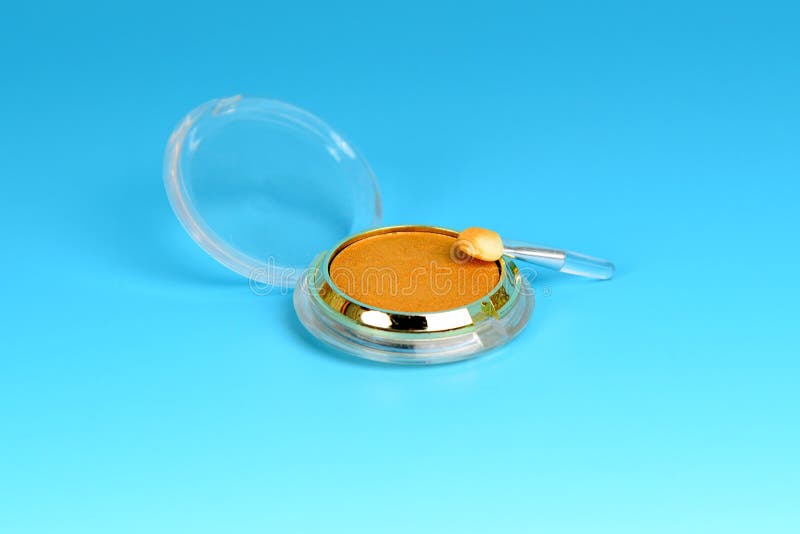 Eyeshadow, Gold Powder for Applying Makeup on a Blue Background Stock ...