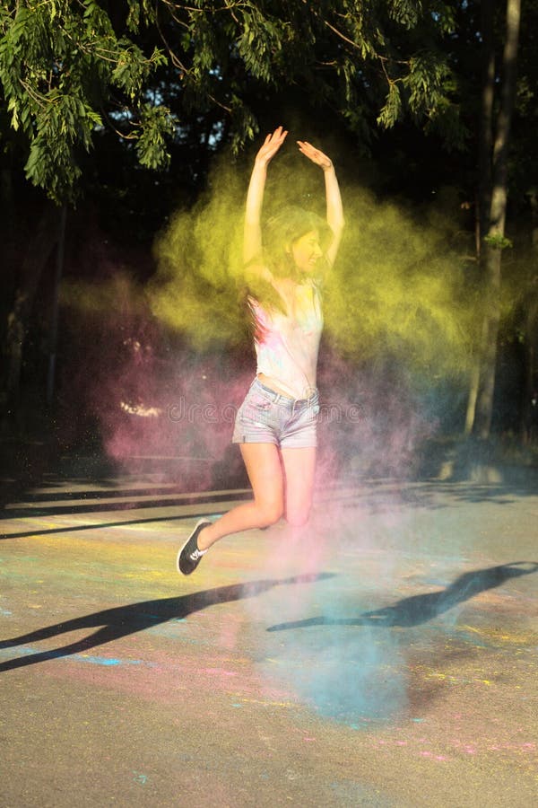 Fabulous Brunette Model Jumping with Exploding Pink, Blue and Ye Stock ...