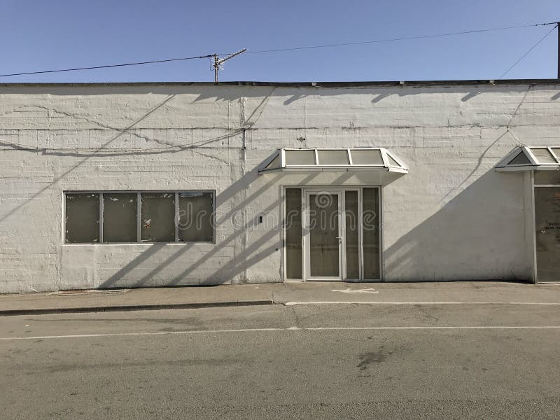 Facade of Abandoned White Washed Building from Outside with Shadows and ...