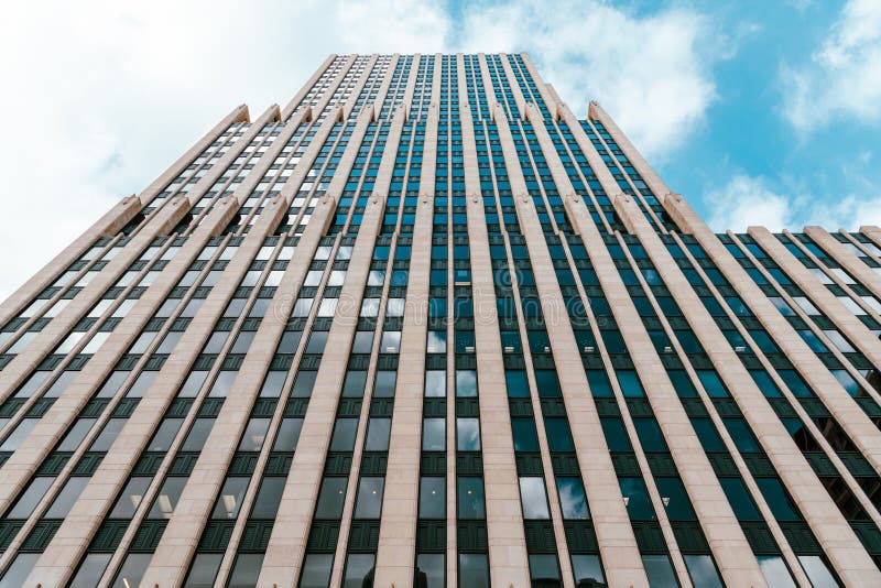 Facade of an Art Deco Skyscraper with Windows Reflecting Sky and Cloud ...