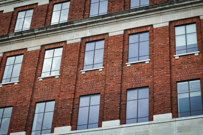 Facade of a Brick Building with Symmetrical Windows Reflecting the Sky ...