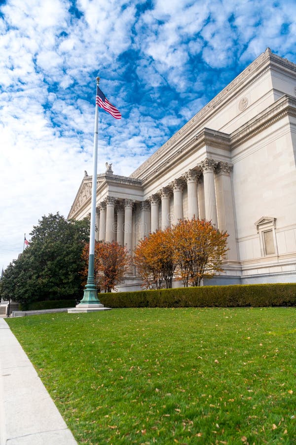 Facade of a Building with Columns and a Mast with the Flag of the ...
