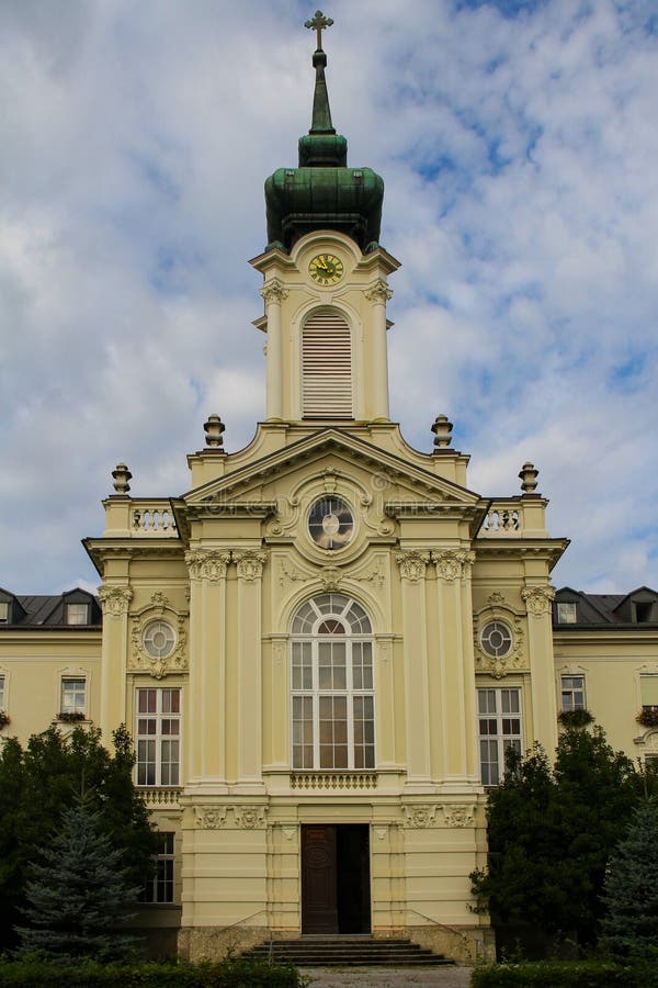 Facade of a Catholic Temple with a Tower Clock Against a Cloudy Sky ...
