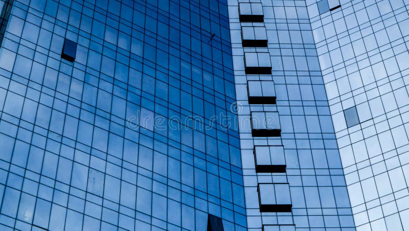 The Facade of a Glass Skyscraper Reflects the Dark Blue Sky at Blue ...
