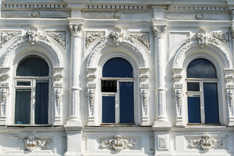 The Facade of an Old Building with Plaster Ornaments and Arched Windows ...