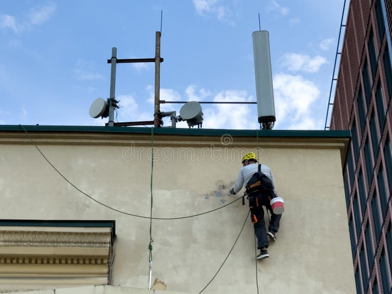 Facade Restoration in Progress with a Professional Worker Using Rope ...