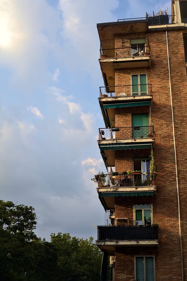 Facade and Roof of a Building Next To Trees with a Cloudy Sunset Sky As ...