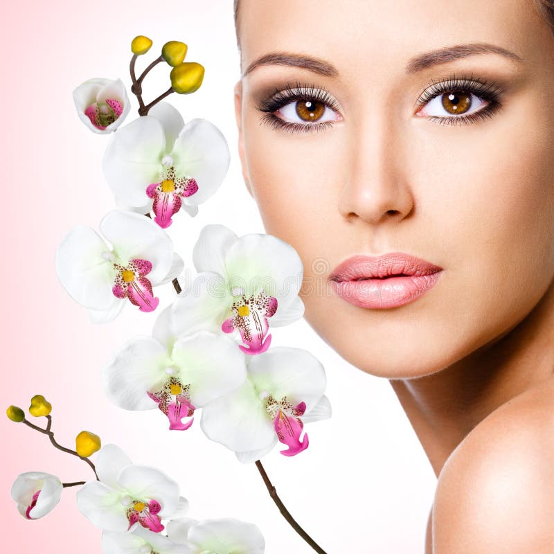 Closeup Portrait Of Beautiful Young Woman With Flower Near Face Stock