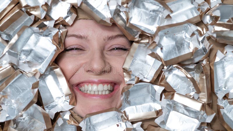 The Face of a Caucasian Woman Surrounded by Candy Wrappers. Stock Image ...