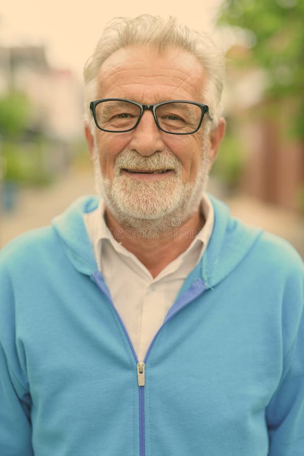 Happy Handsome Senior Bearded Man Smiling While Talking On Mobile Phone
