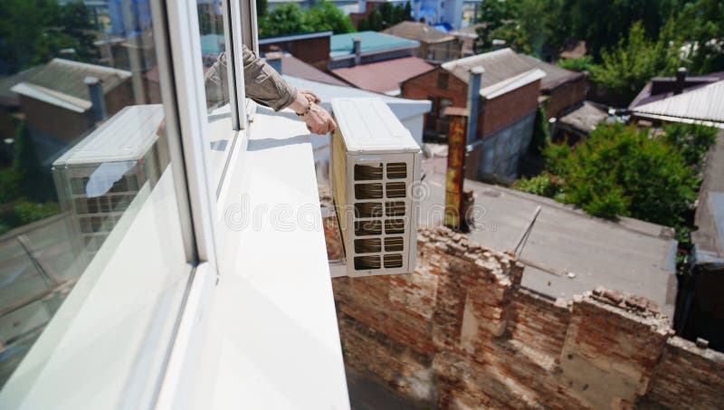 Without a Face. a Man Installs an External Air Conditioner. Dangerous ...