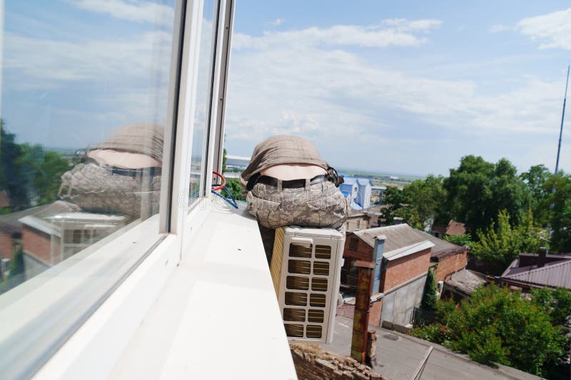 Without a Face. a Man Installs an External Air Conditioner. Dangerous ...