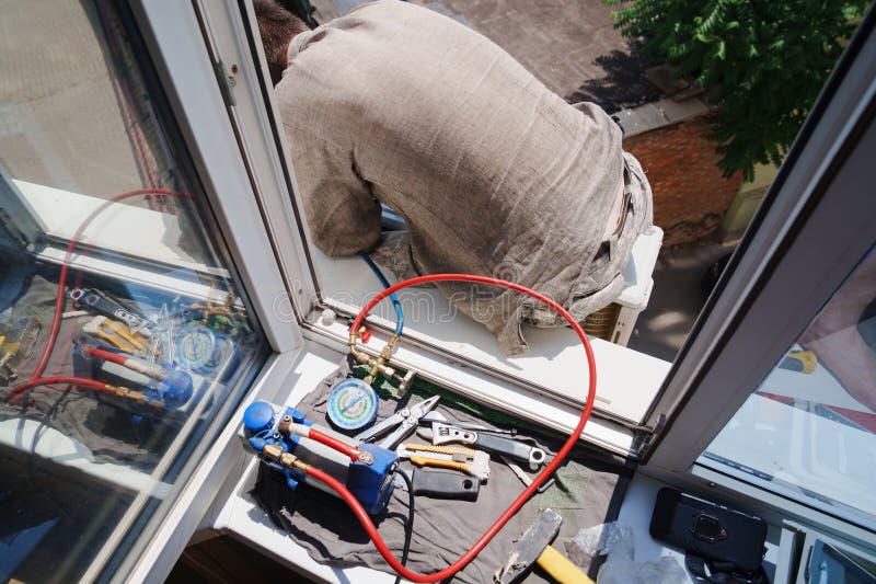 Without a Face. a Man Installs an External Air Conditioner. Dangerous ...