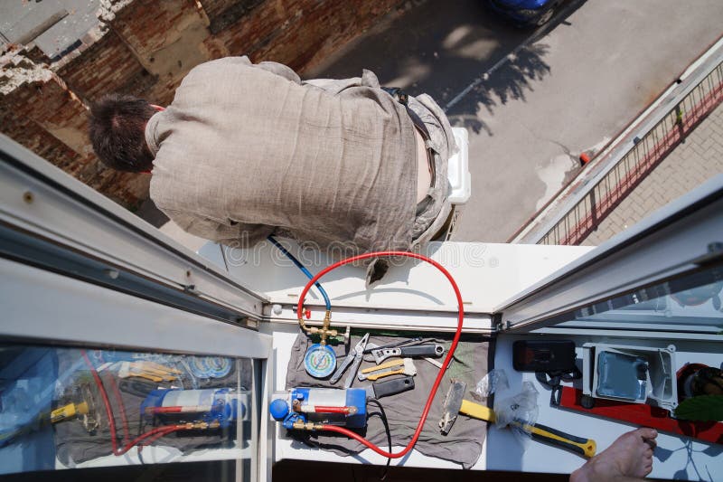 Without a Face. a Man Installs an External Air Conditioner. Dangerous ...